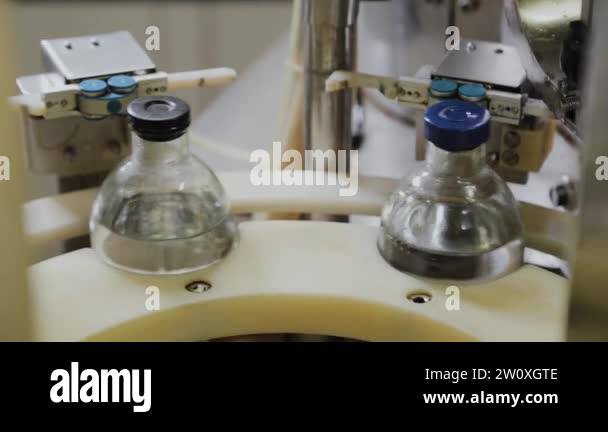 Pouring medicine on an assembly line into glass bottles for injection ...