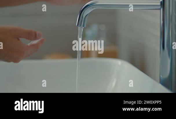 Body care. Person rinsing hands in modern design bathroom at home. Man ...