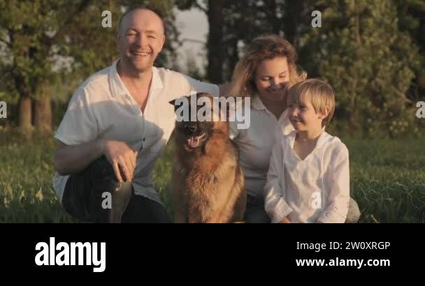 Happy family with a dog in nature. 7 year old boy with his parents ...
