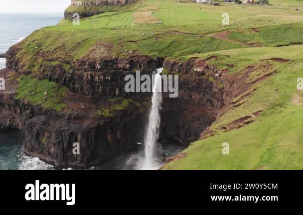 Stunning waterfall splashing from cliff aerial view. Mulafossur ...
