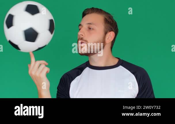 Soccer football player spinning a ball on a finger, green screen ...