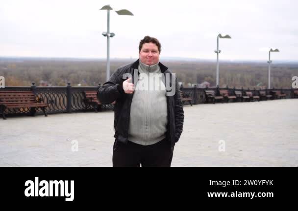 Zoom in portrait of fat man looking at camera and showing thumb up ...