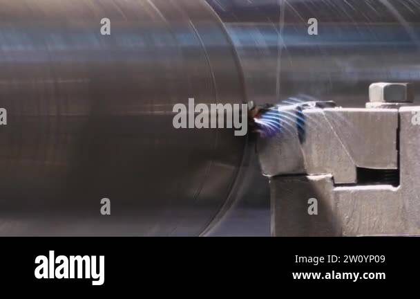 Close up of a CNC machine threading a steel roll. Twisted chips come ...