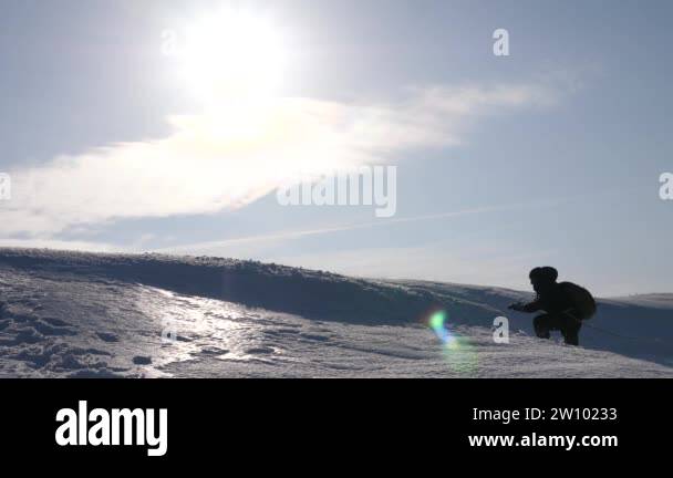 Travelers climb rope to their victory through snow uphill in a strong ...