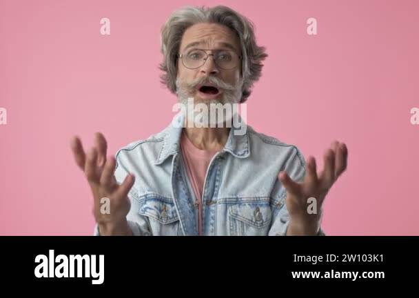 Displeased elderly stylish bearded man with gray hair in denim jacket ... Displeased elderly stylish bearded man with gray hair in denim jacket ...