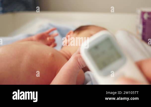Mother or father measuring baby temperature with digital Non-contact ...