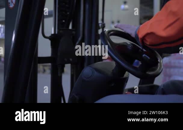 operator controls loader sitting behind wheel driving past the shelves ...