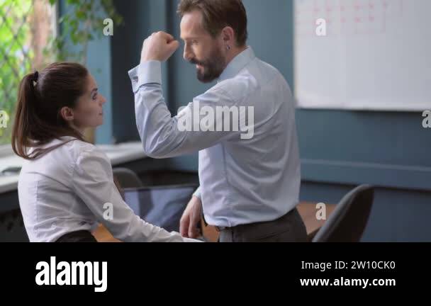 Rear view. Business man showing off to employee female the strength of ...