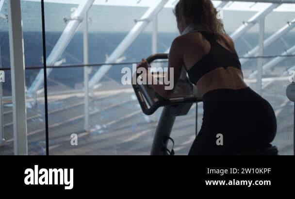 Young beautiful girl in gym, legs on cycling simulator. The concept: to ...