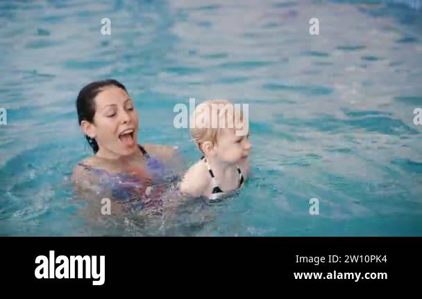 Swimming pool. Mom teaches a young child to swim in the pool Stock ...