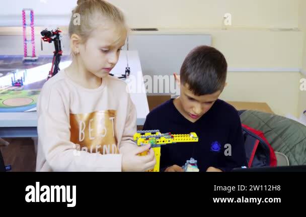 school children, boys and girls, play with a toy designer, create ...