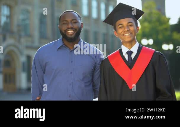 Proud glad father hugging graduating son with diploma, education degree ...