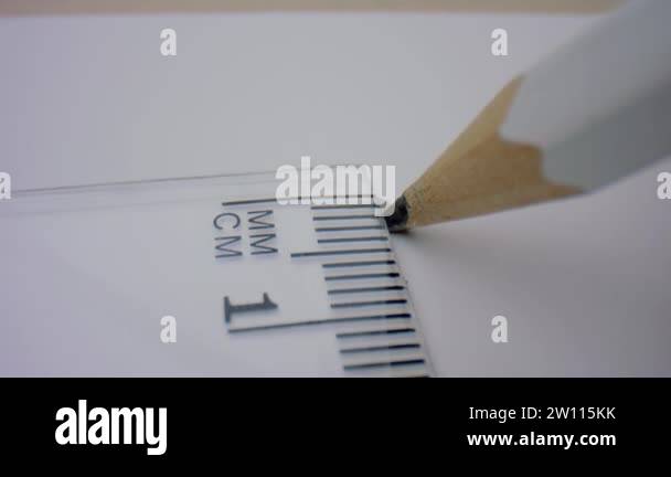 Pencil drawing straight line on paper. Architect using ruler for sketch ...