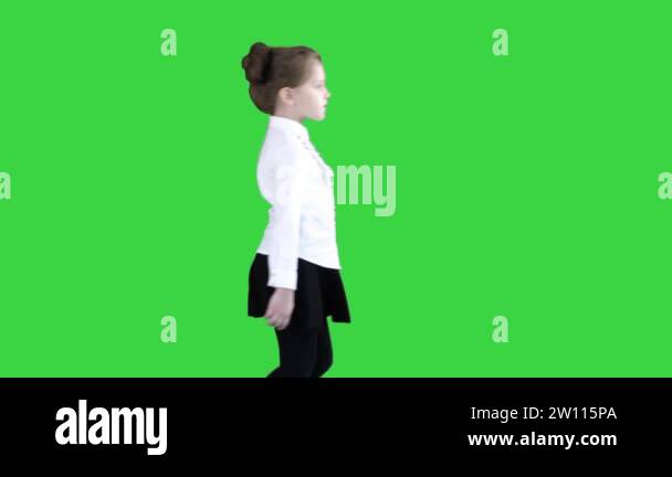 Little girl in school uniform walking by on a Green Screen, Chroma Key ...