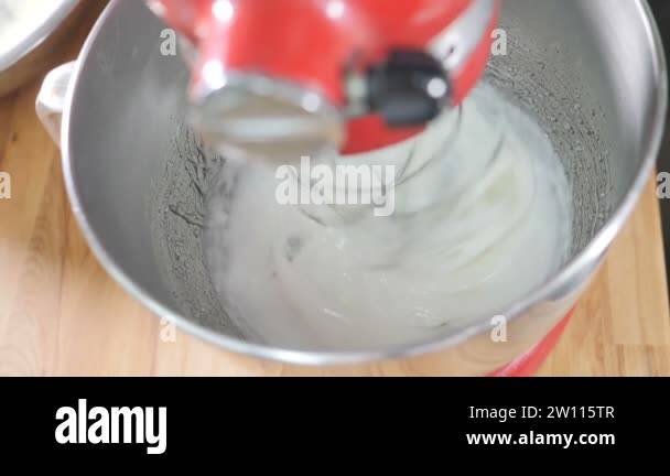 Dessert cooking. Whipping white cream with a mixer in slow motion ...