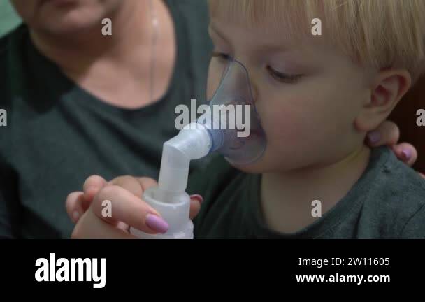 A child of three years old breathing in an oxygen mask. Inhalation of ...