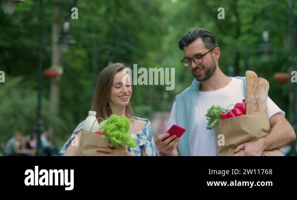 Handsome man showing his pretty girlfriend funny video while they ...