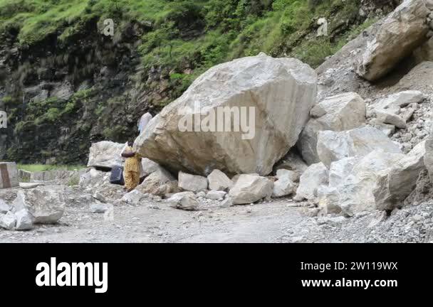 Boulders and smaller rocks roll and slide down close the road in india ...