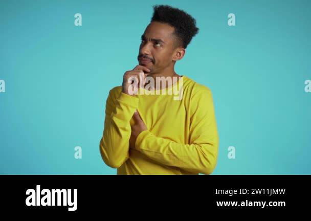 Thinking man looking up and around on blue background. Worried ...