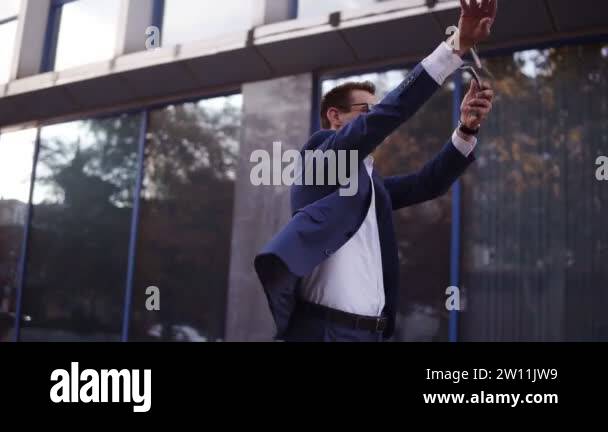 Happy young businessman in blue suit walks in exitement and throw ...