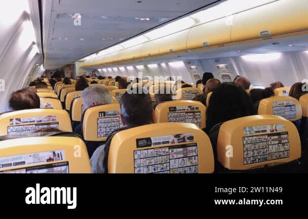 Passengers inside a Ryanair aircraft cabin, during flight. Interior of ...