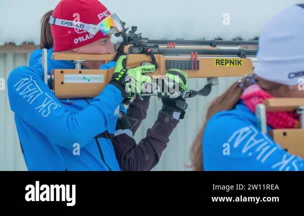 Two girls are standing up and they are shooting with the rifle. They ...
