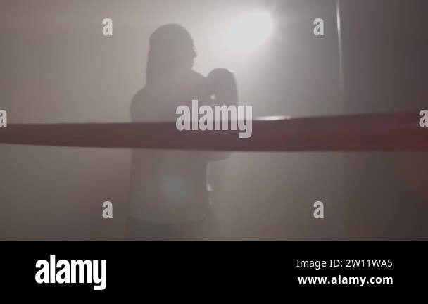 Slowmo of muslim woman in hijab fighting punching bag in misty ...