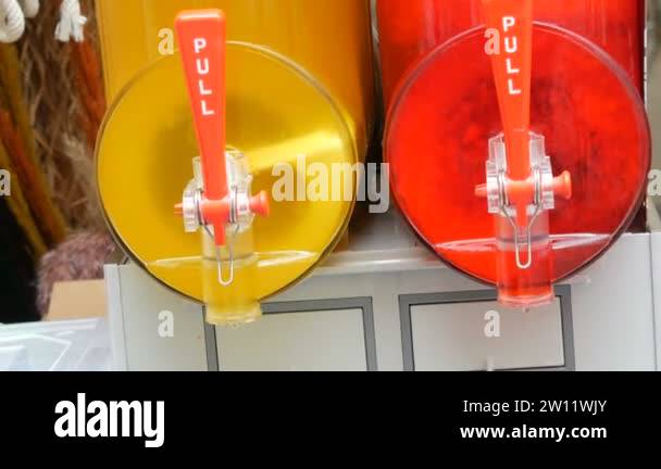 Iced juice machine juicer containing row of red and yellow slushes ...