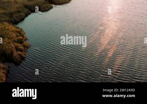 Flying over rippled water of lakes among grass near Black Sea, flying ...