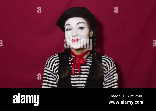 Beautiful girl mime smiles and makes a gesture of a beating heart with ...