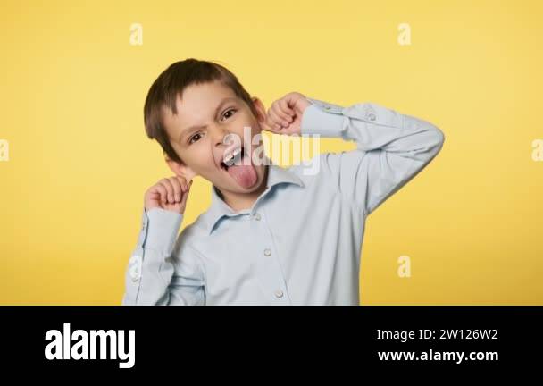 Funny little boy making silly faces looking at camera. Boy in blue ...