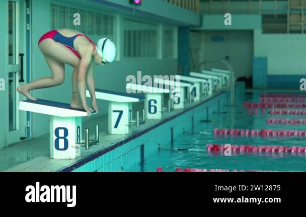 Teenager girl Swimmer Dive In Swimming Pool. Female swimmer dives in ...