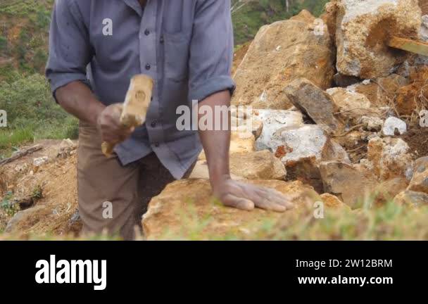 Side view of unrecognizable indian man cutting a block of granite with ...