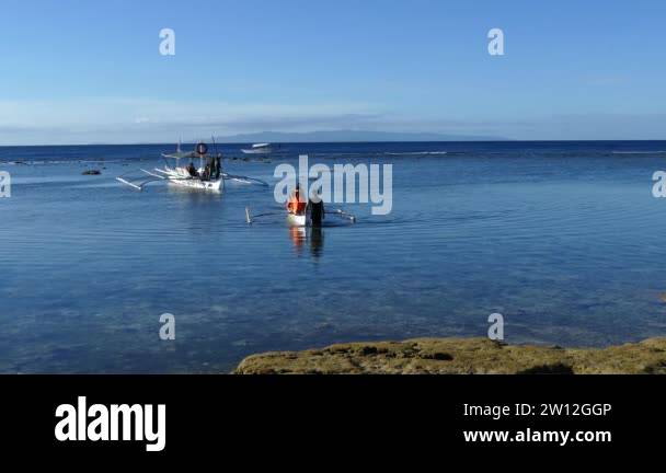 Catamaran Boat arrives at the reef and with a small boat people come to ...