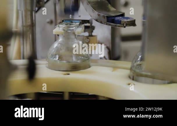 Pouring medicine on an assembly line into glass bottles for injection ...