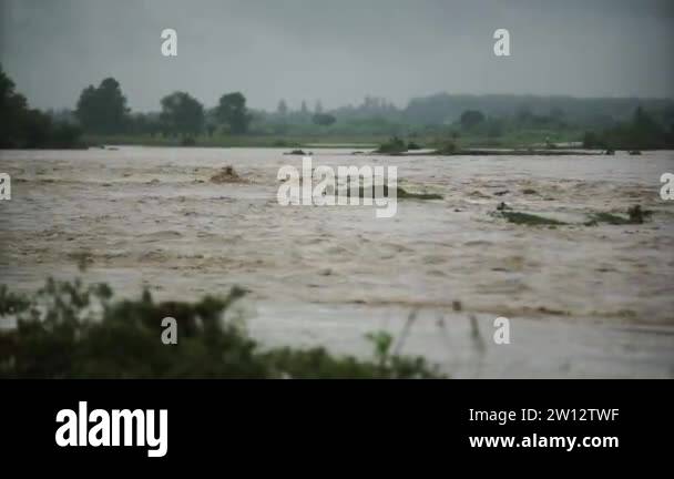 Natural disaster . Fast flowing raging river. Soil and mud is moving ...