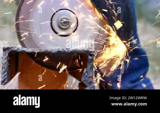 Metal cutting with a cutting wheel of an angle grinder. Sparks fly from ...