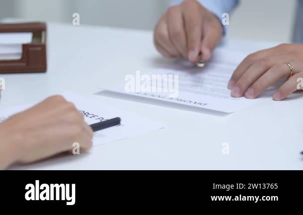 Couple signing divorce policy, woman taking off engagement ring from ...