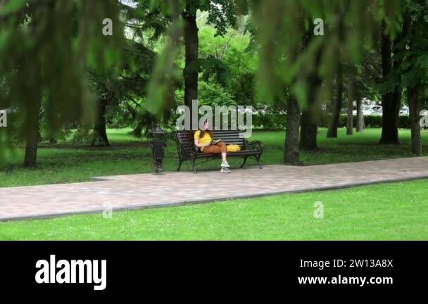 The camera from behind the spruce branches follows a teenage girl ...