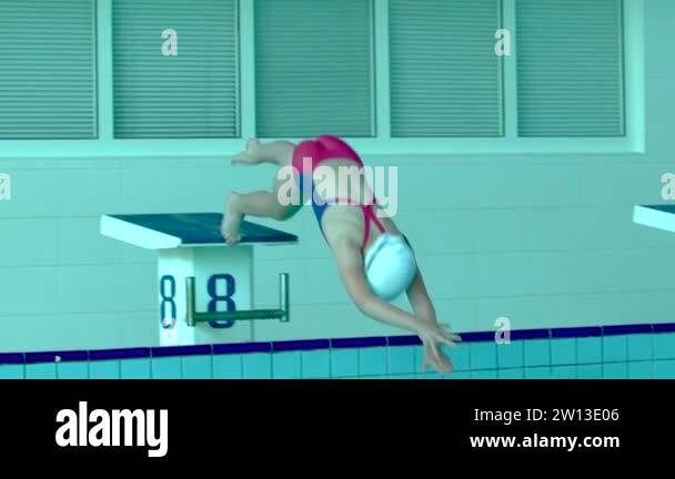 Male swimmer jumps off starting block and start swims in pool HD slow-motion video. Professional ...
