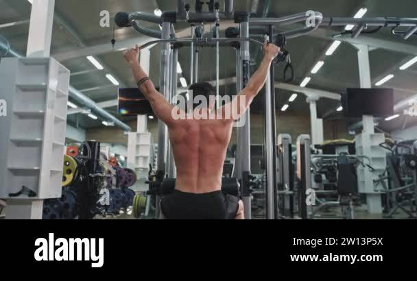 Big gym class athletic guy exercises hard doing exercises for his back ...