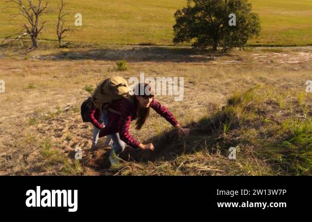 travelers teamwork. tourist with backpacks help climb each other up the ...
