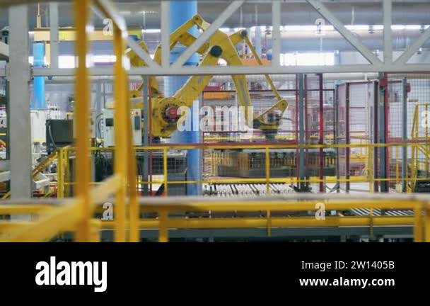 Robotic machine moving bricks on a line at a modern industrial factory ...