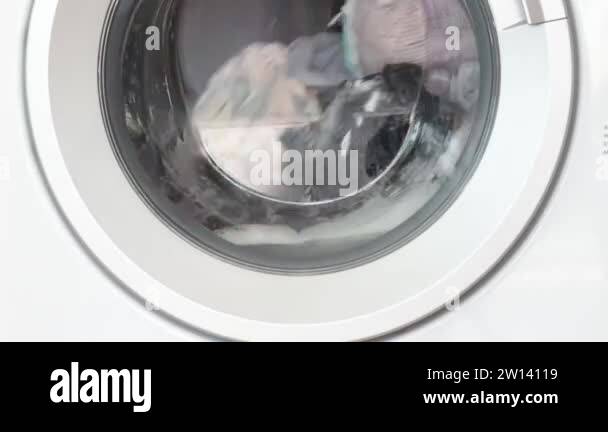 washing machine working with rotating garments inside, process of ...