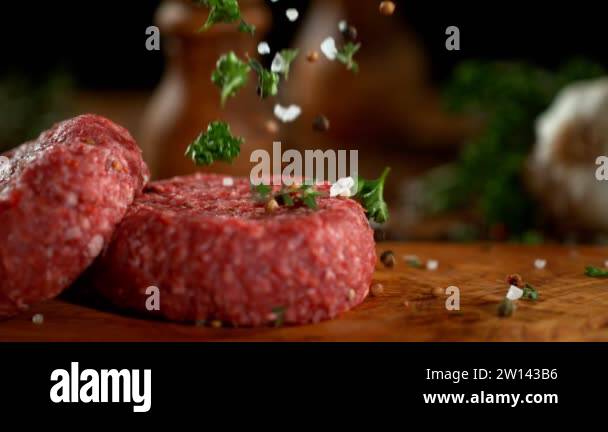 Pieces of minced beef hamburger with falling spice with side move on ...