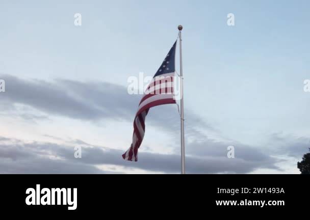 american flag waving at the top of a tall flag pole Stock Video Footage ...