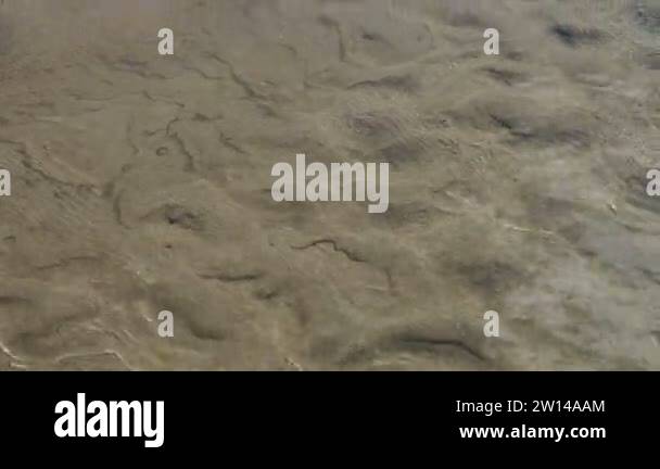 Yellow sand is visible through the clear wavy river water. Crystal ...