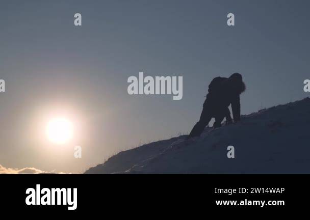 Man climber descends slowly from snowy mountain in order not to fall ...