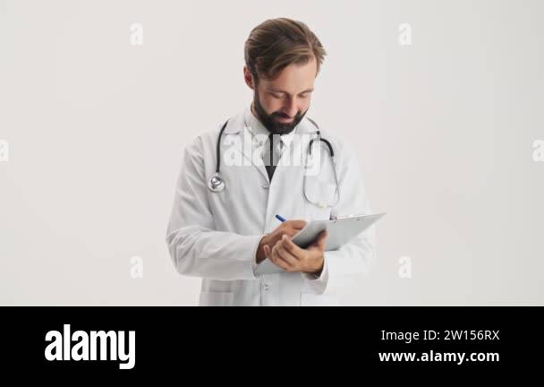 Attractive young bearded man doctor in white professional coat with ...