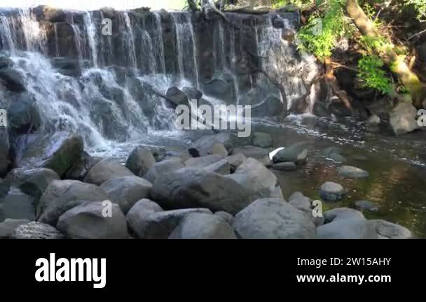 Beautiful waterfall video panning from up as water splashes and ...